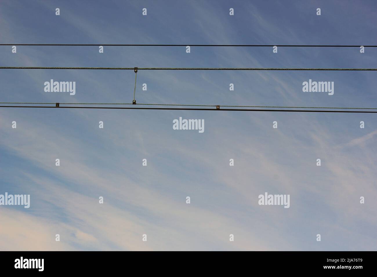 Electrical power lines crossing overhead against the sky in black and ...