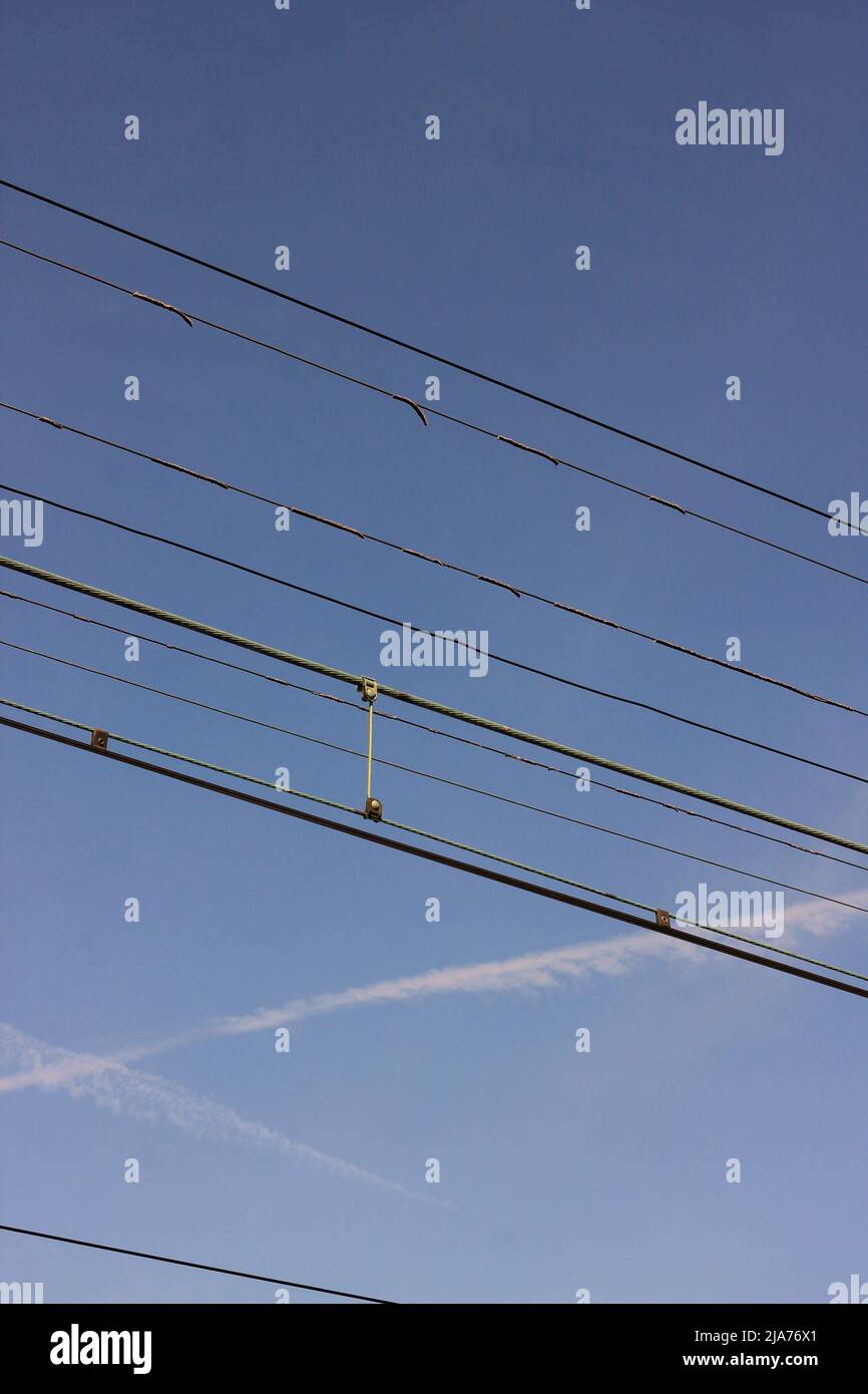 Electrical power lines crossing overhead against the sky in black and ...