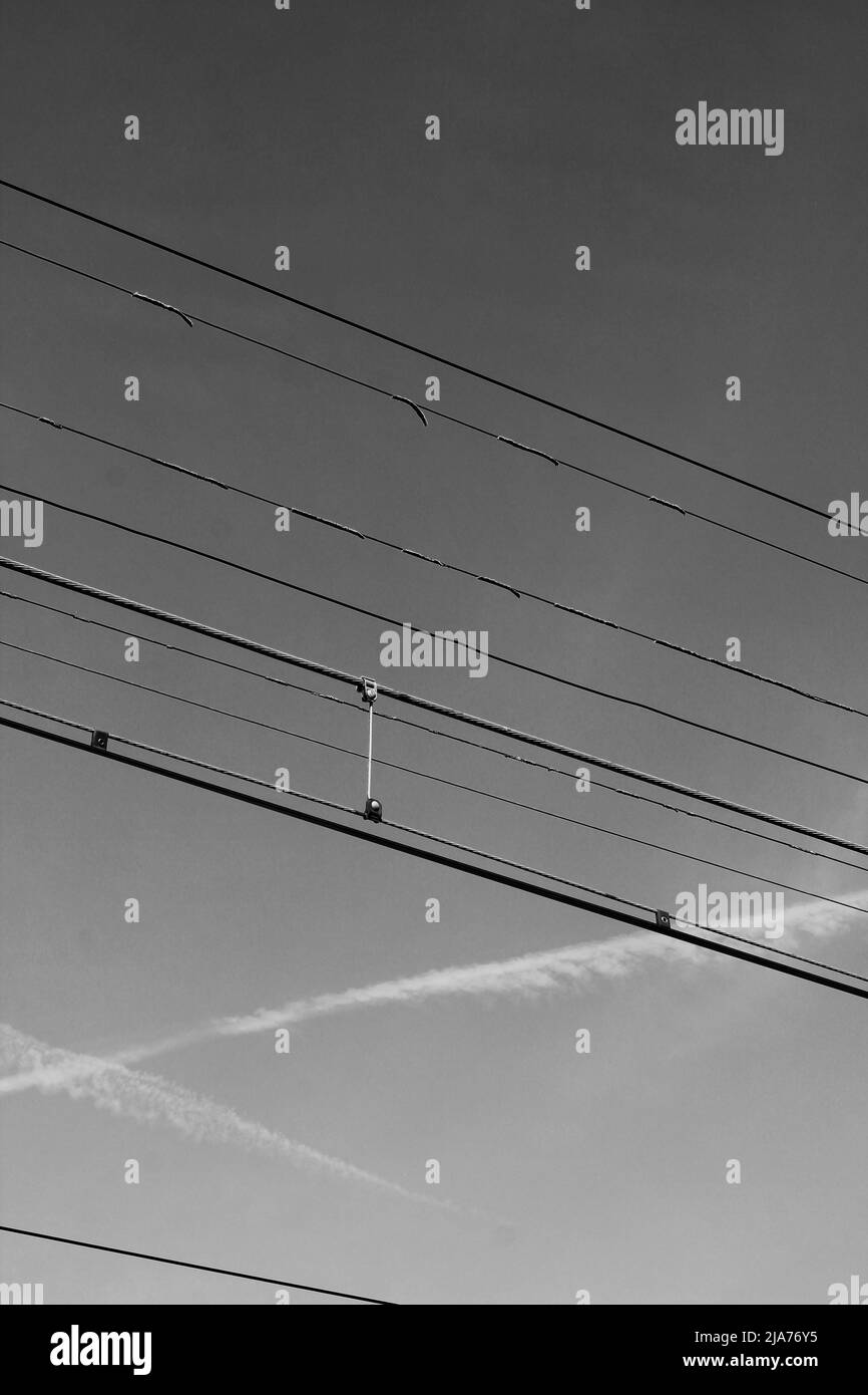 Electrical power lines crossing overhead against the sky in black and ...