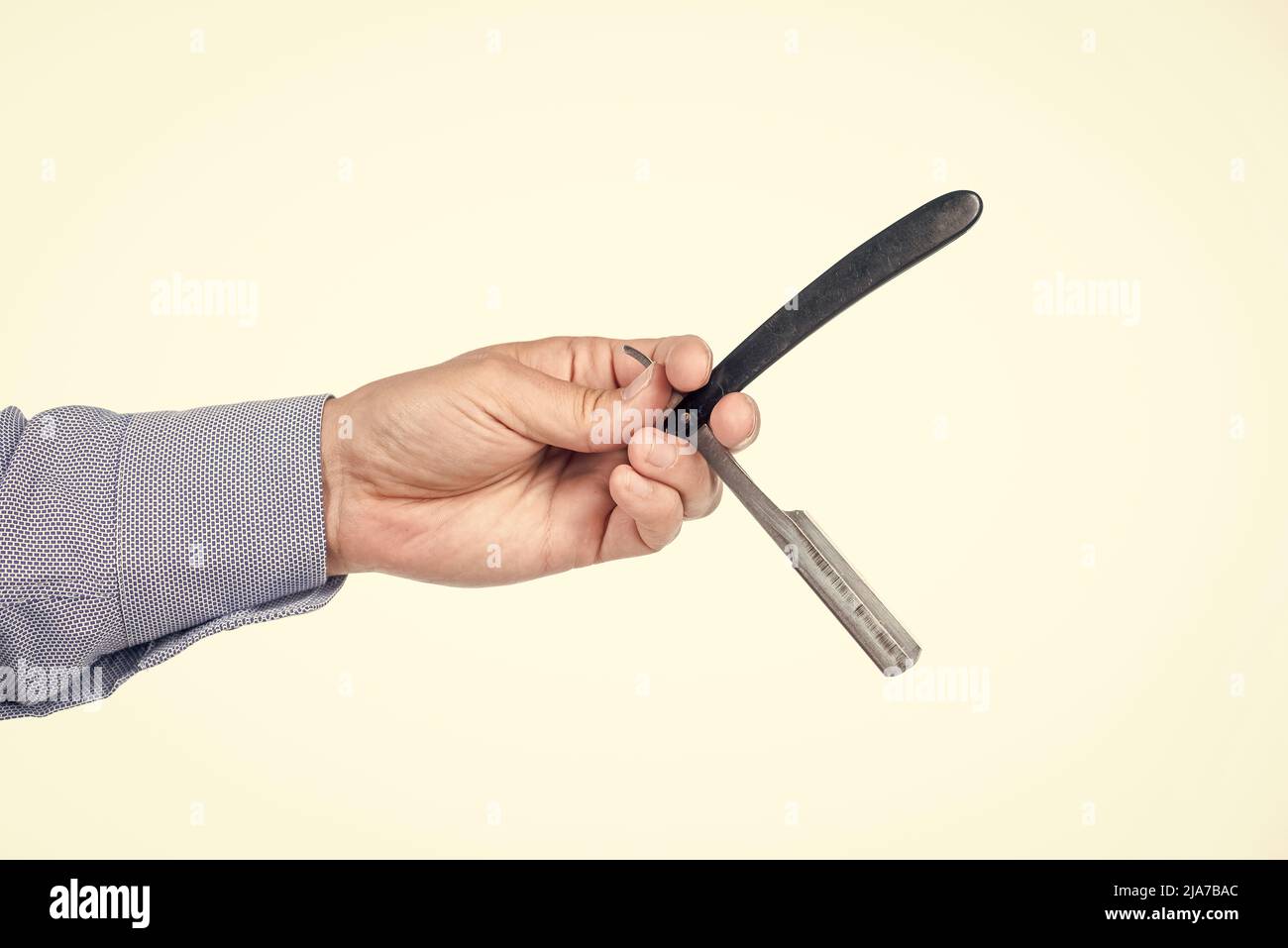 retro razor blade in hand of man isolated on white. hairdresser concept ...