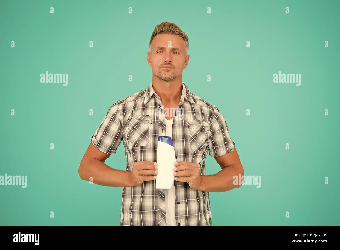 Skincare for your scalp. Man hold shampoo bottle blue background. Hair ...