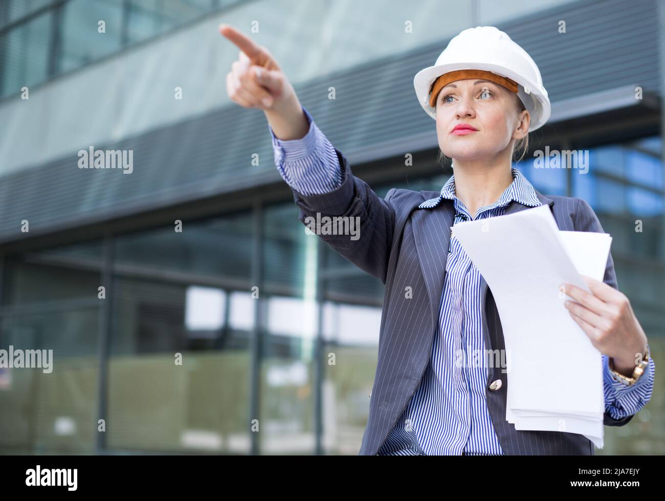 Professional woman pointing finger on object Stock Photo - Alamy