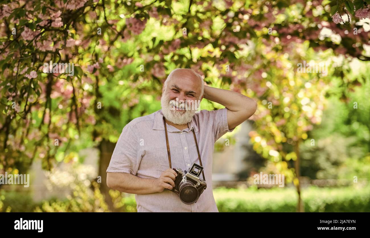 Hobby and leisure. Experienced photographer in spring garden. Cameraman ...