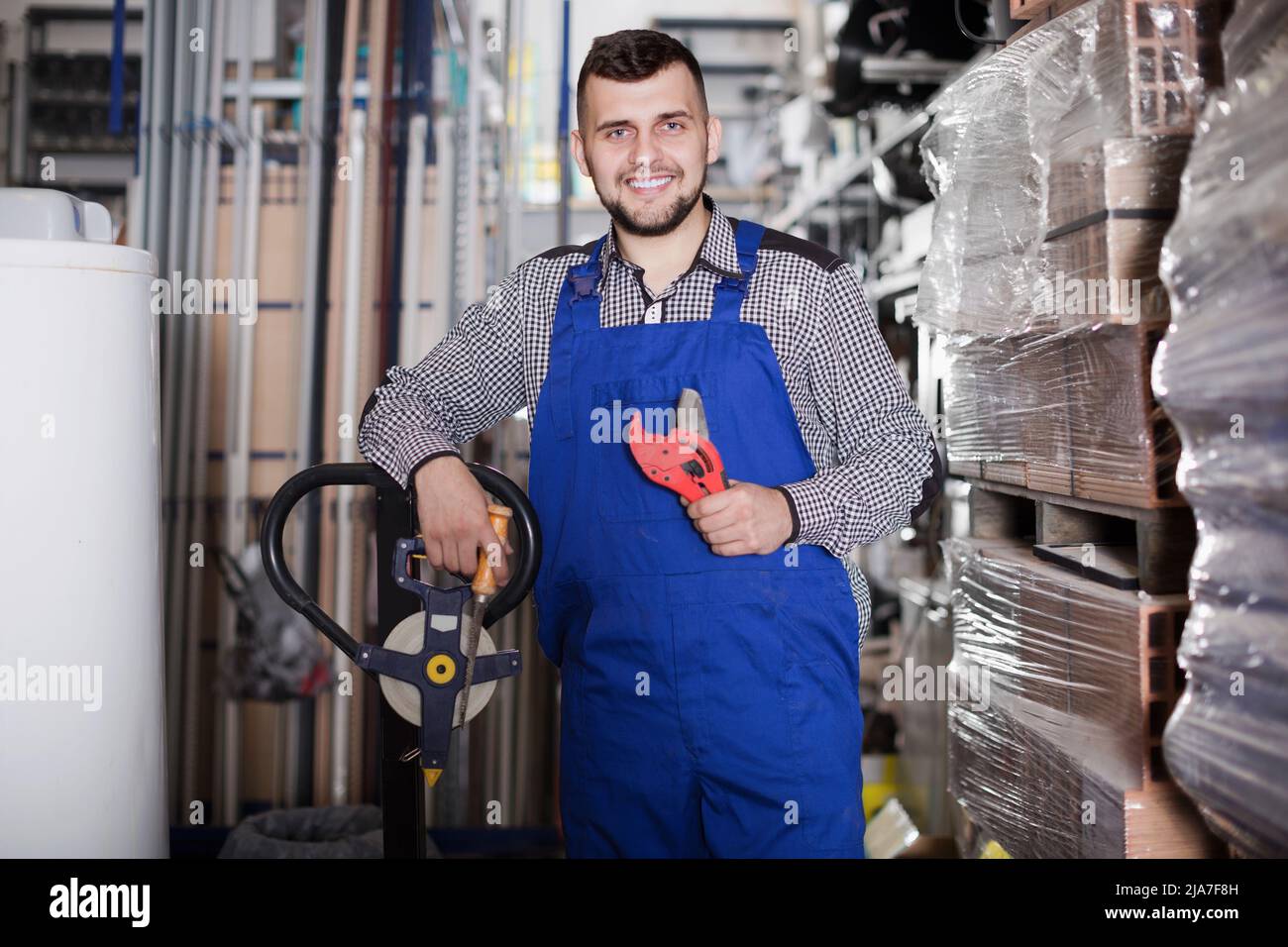 Positive builder man demonstrating various tools Stock Photo - Alamy