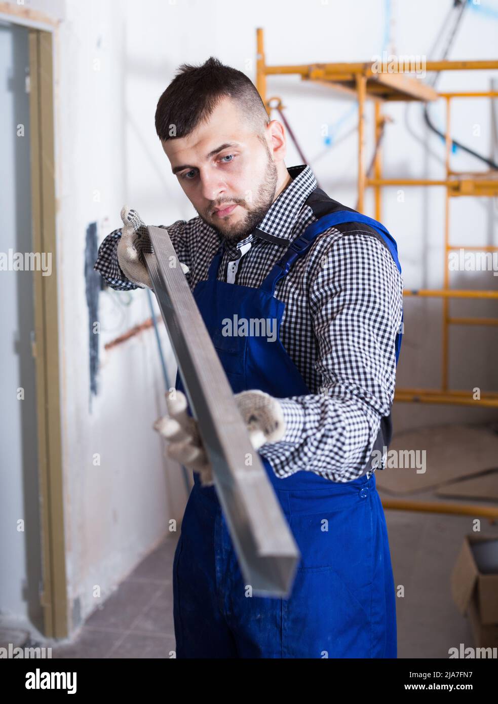 Male worker is looking at the level of the profile Stock Photo - Alamy