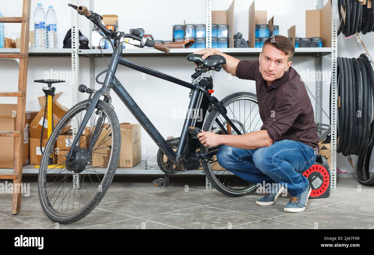 Portrait of adult master repairing bicycle Stock Photo - Alamy