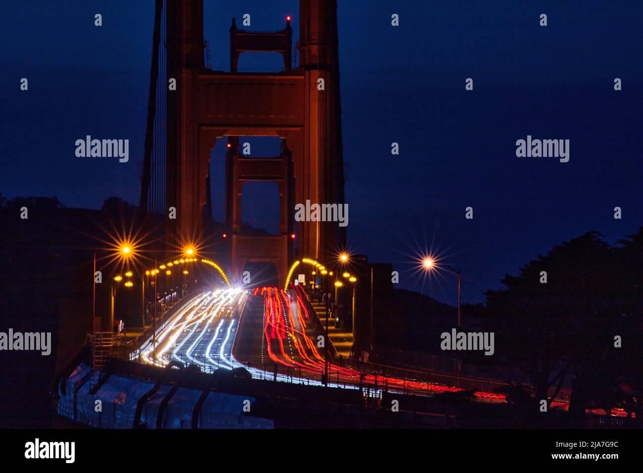 Blurred traffic driving through Golden Gate Bridge at night Stock Photo ...