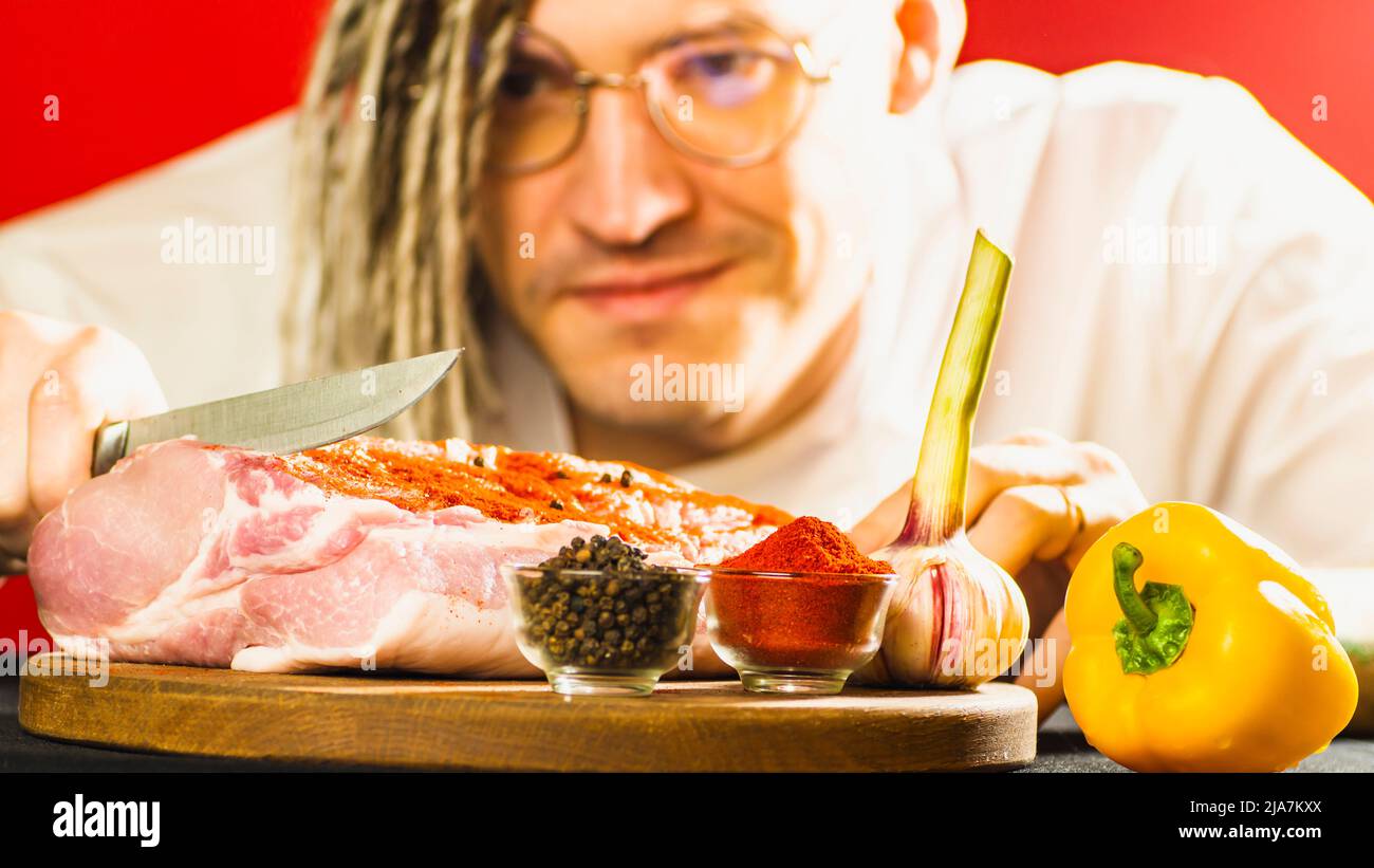 Large chunk of raw pork meat on wooden board with spices, vegetables ...