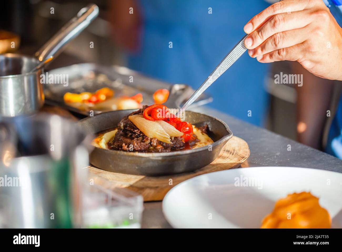 Close up of chef hands in luxury hotel or restaurant kitchen decorating ...