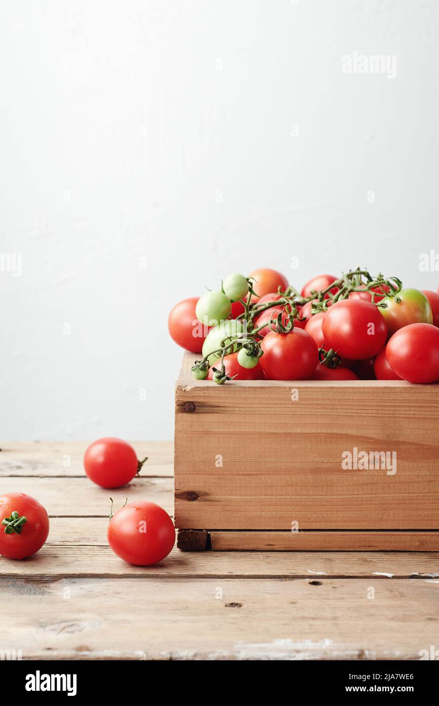 Red vine tomatoes in a wooden box. Cherry tomato Stock Photo - Alamy