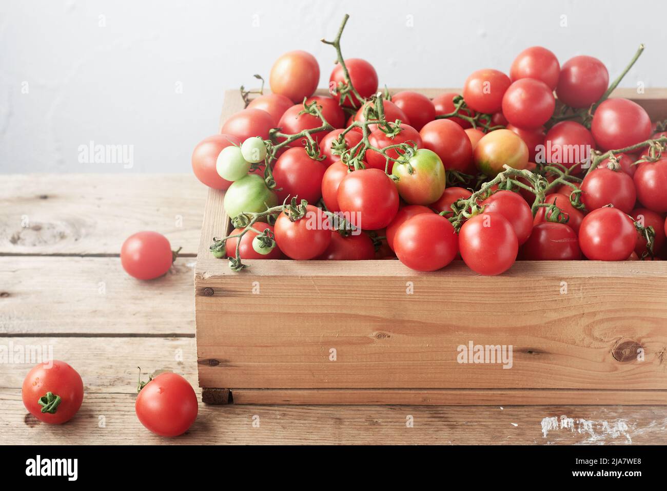 Red vine tomatoes in a wooden box. Cherry tomato Stock Photo - Alamy