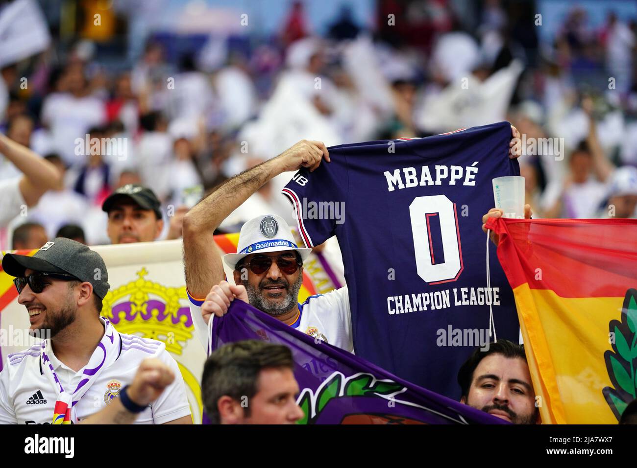 A Real Madrid fan holds up a Kylian Mbappe shirt signaling the number ...