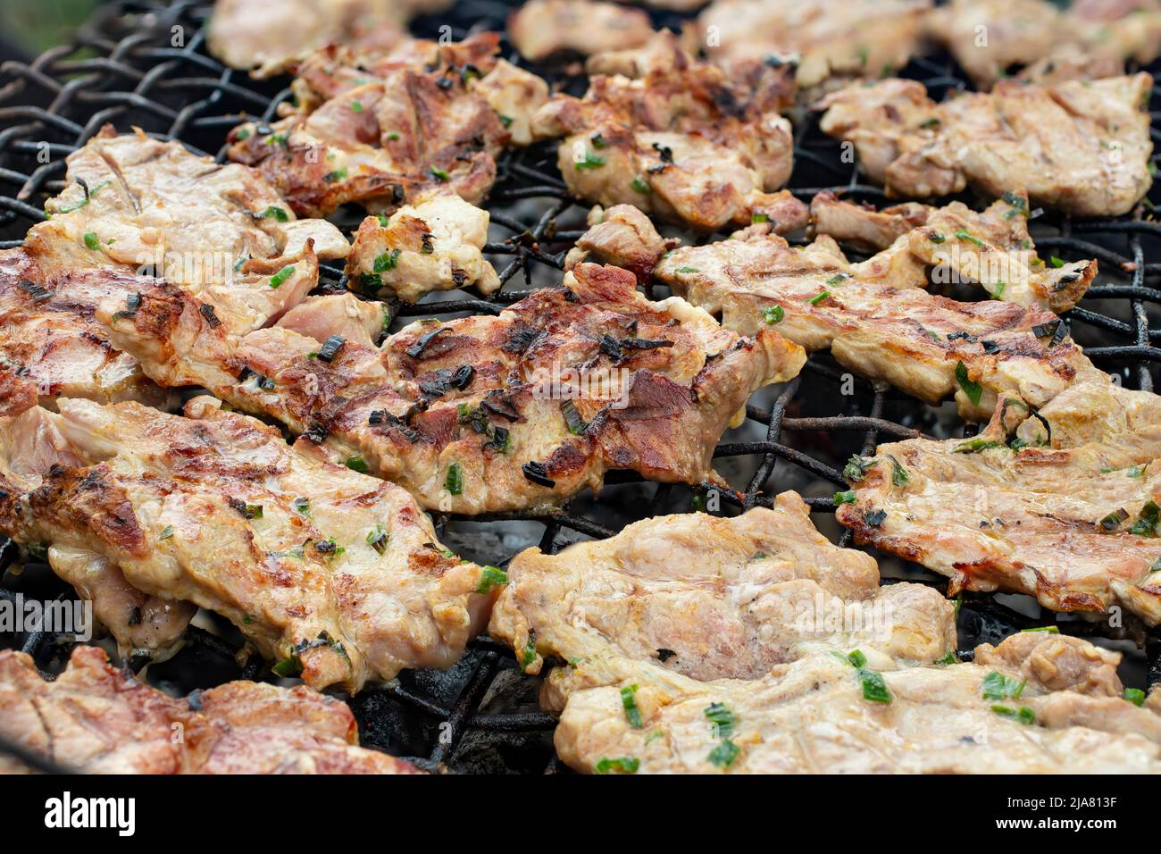 Pork neck slices cooking on a grill, side view Stock Photo - Alamy