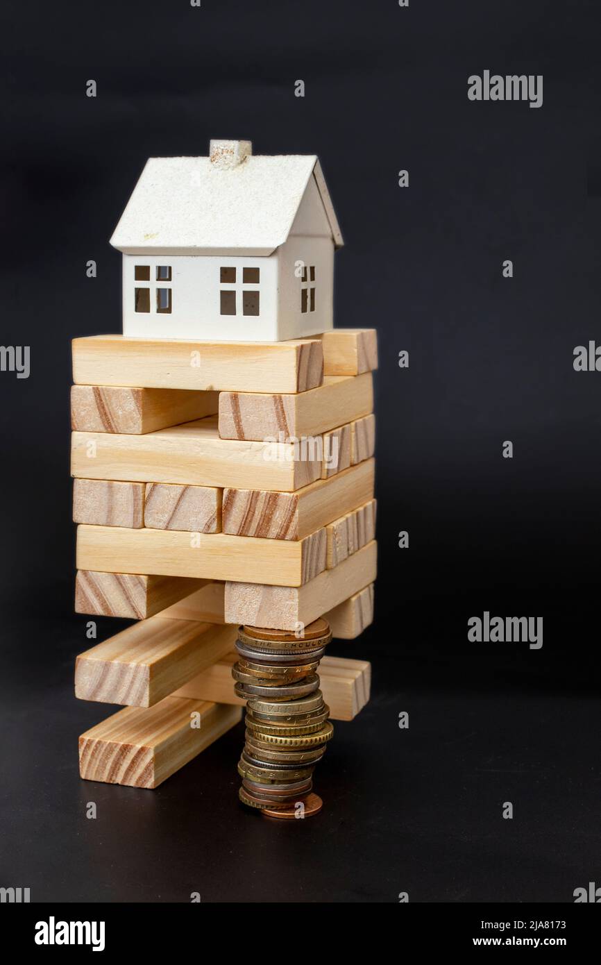 Model house on top of a wood blocks tower, supported by a high stack of ...