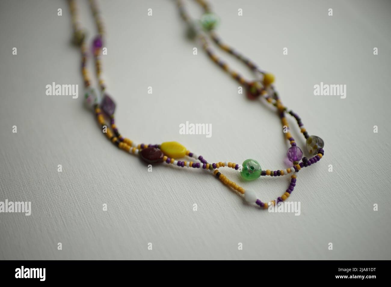Beaded beads and different stones on a white texture table Stock Photo ...