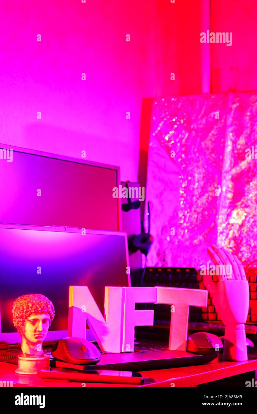 NFT (Non-Fungible Token) and computer equipment in pink neon light. NFT ...