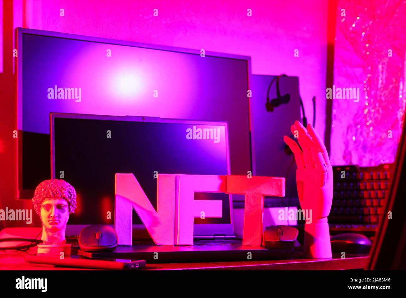 NFT (Non-Fungible Token) and computer equipment in pink neon light. NFT ...