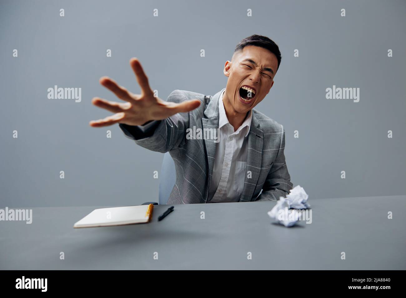 Asian man in a gray suit crumpled paper office official emotions ...
