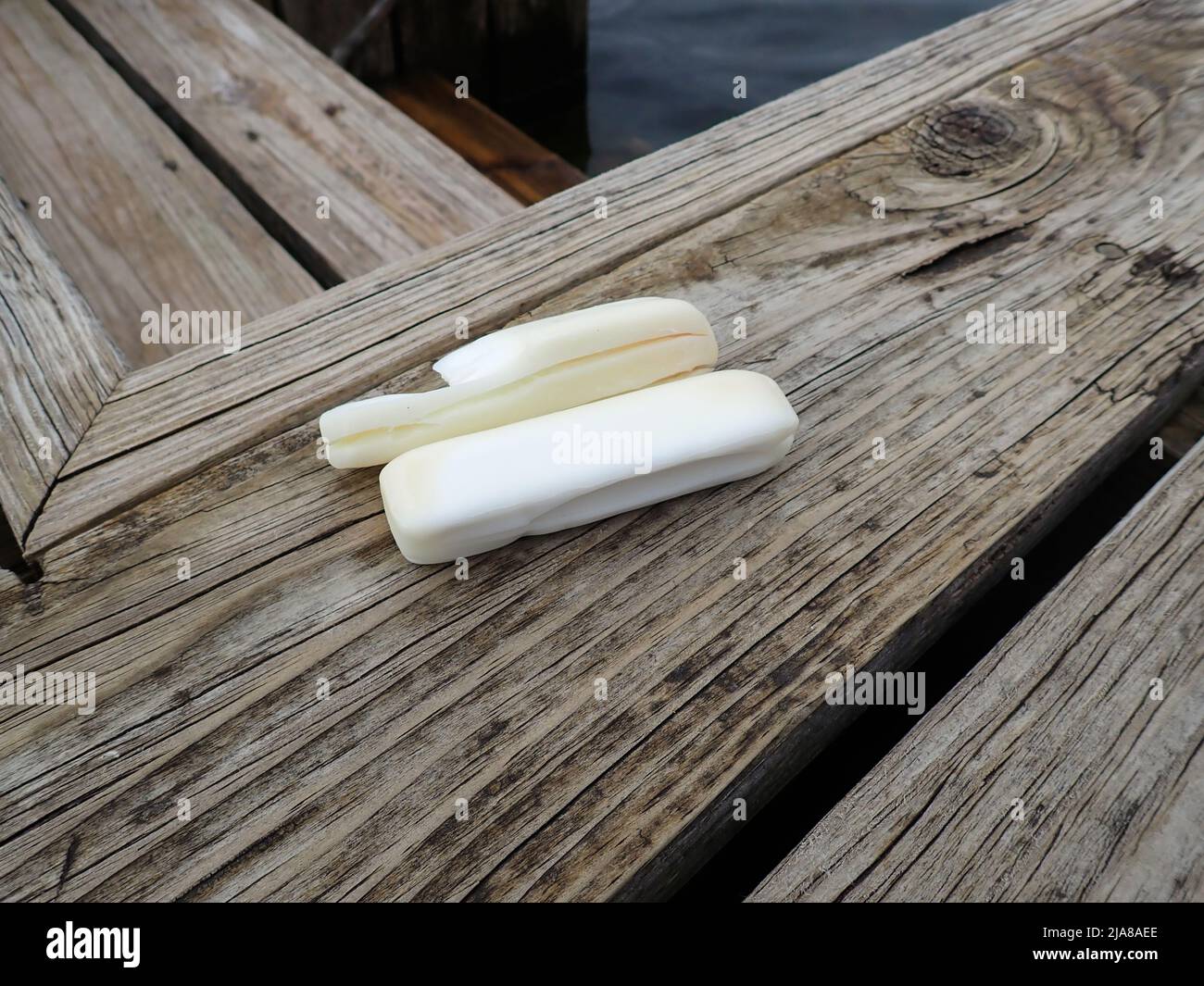 Slivers remaining from a bar of soap sitting on the worn wood of an old ...