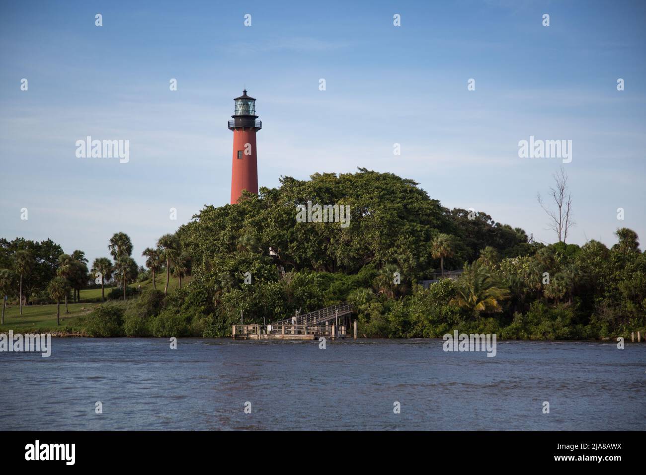 A lighthouse and it's surrounding landscape with a walkway and leading ...