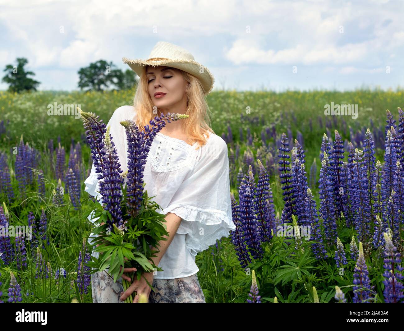 Woman walking through a blooming meadow Stock Photo - Alamy