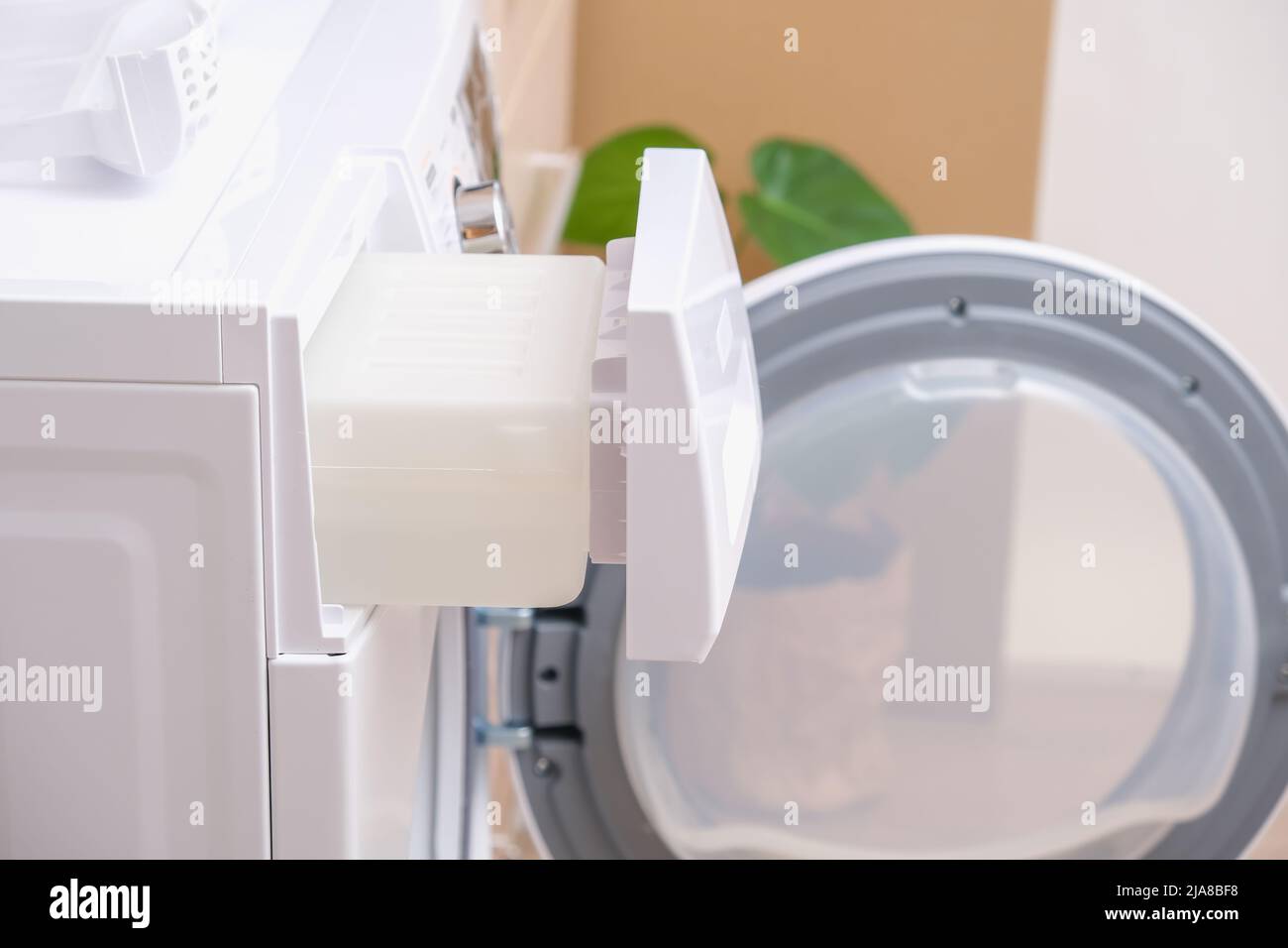 A man takes out a container from the dryer to collect water squeezed ...
