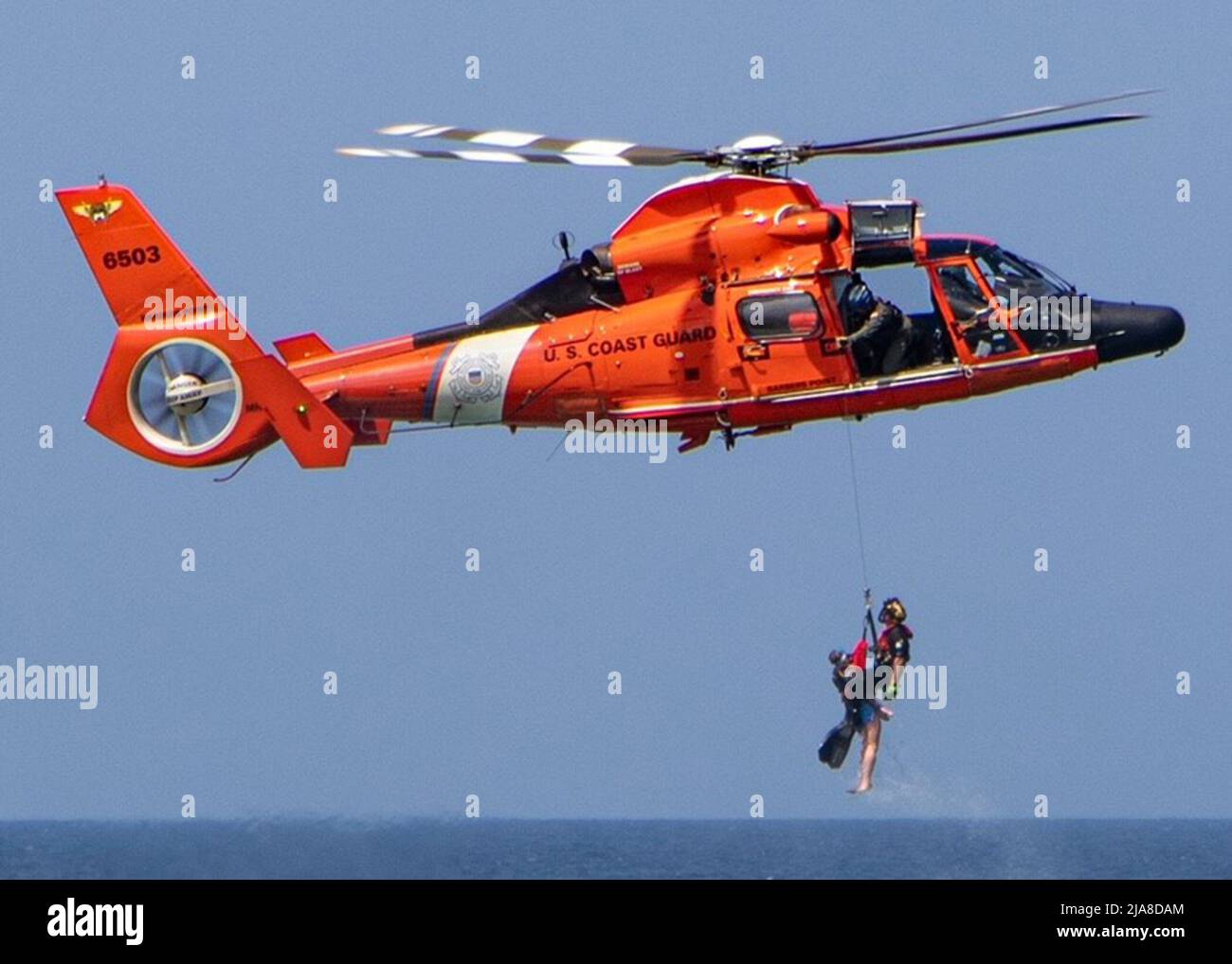 An Air Station Barbers Point MH-65 Dolphin helicopter crew retrieves a ...