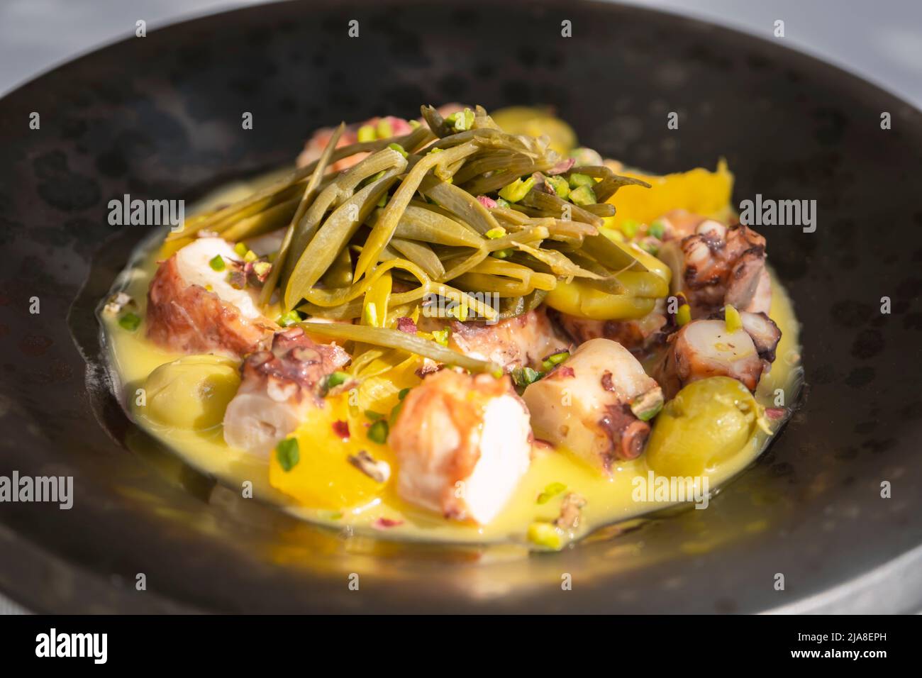 Octopus dish with orange fruit and lemon sauce on a luxury restaurant ...