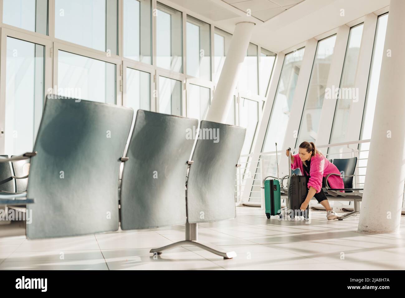 Portrait of woman wearing black clothes, pink cardigan, sitting on ...