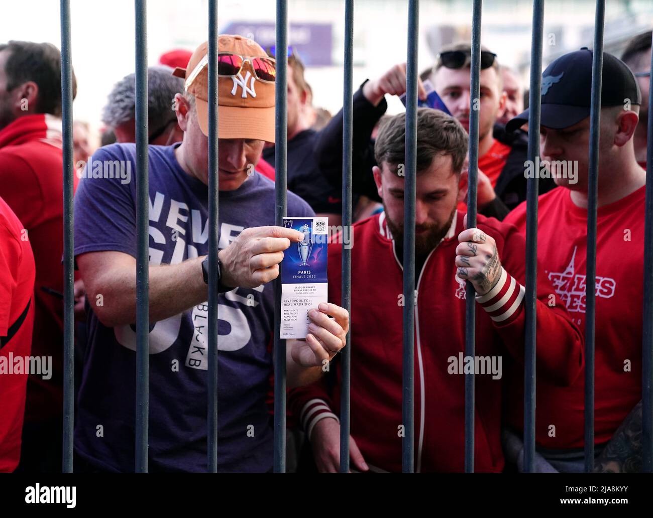 Liverpool fans stuck outside the ground show their match tickets during ...