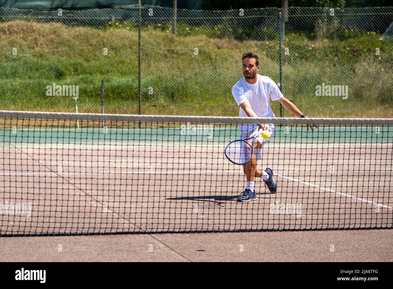 Tennis player performing a drop shot on court Stock Photo - Alamy