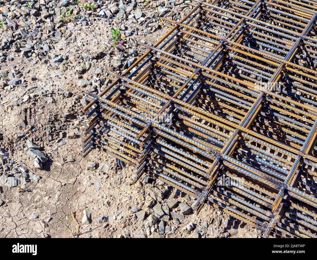 reinforcing mesh lies on the ground, waiting to rise to the mounting ...