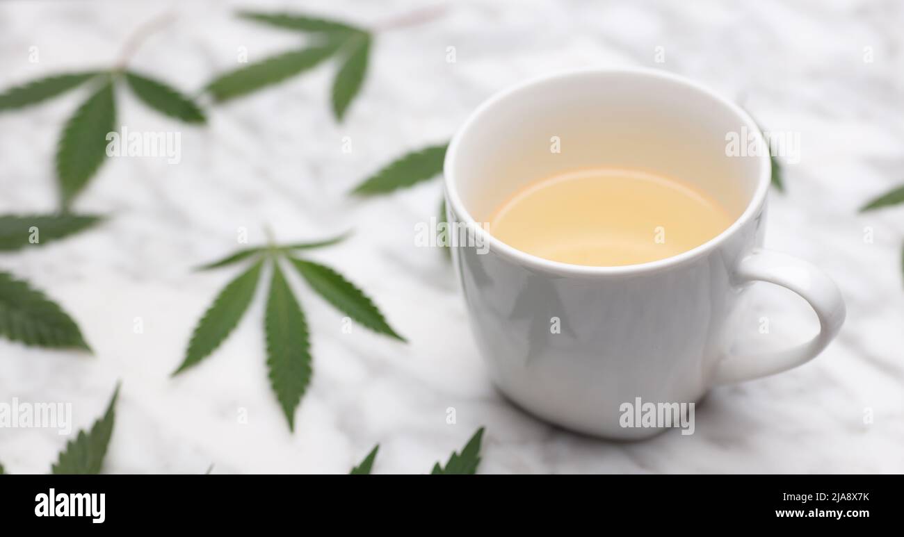 marijuana-infused white mug, on marble table with leaves Stock Photo ...