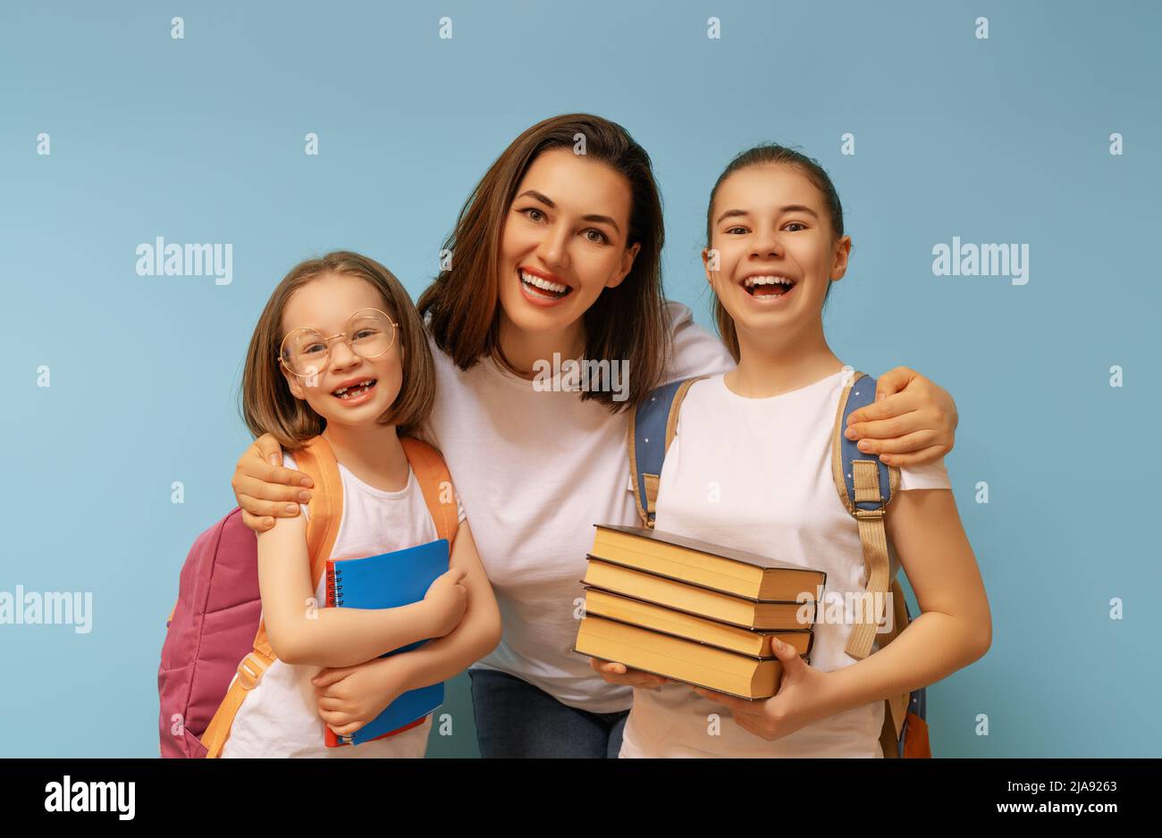 Two schoolers children and their mother teacher on light blue ...