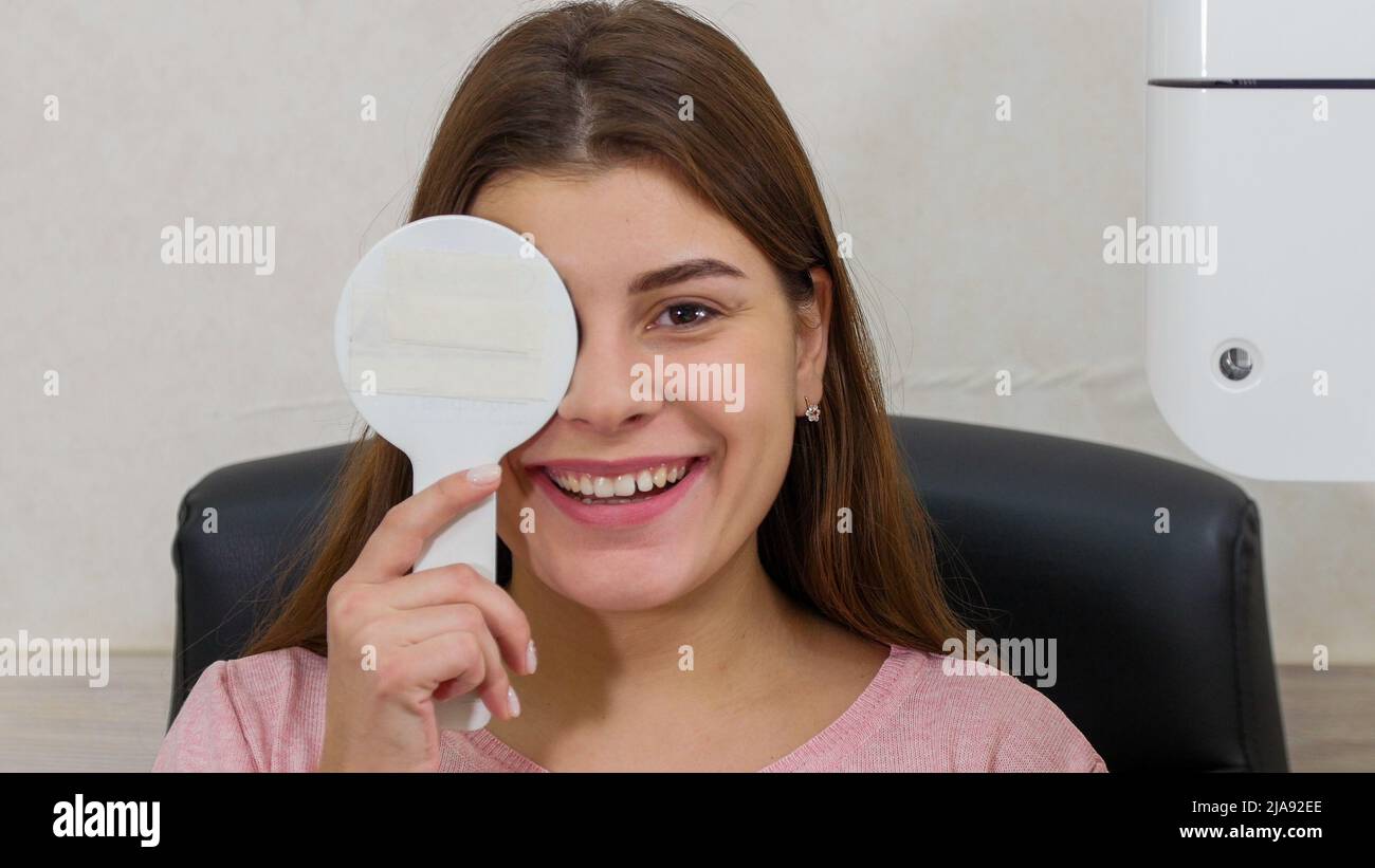 Ophthalmology treatment - young smiling woman checking her visual ...