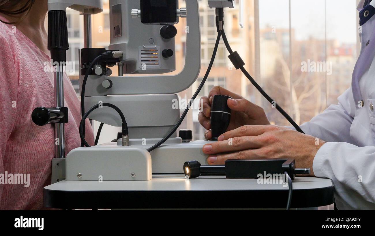 Ophthalmology treatment - a doctor checking young woman's visual acuity ...