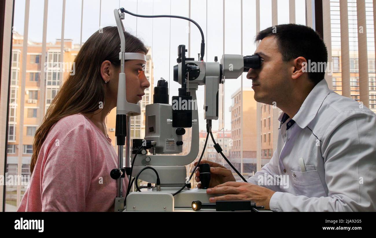 Ophthalmology treatment - young woman checking her visual acuity with a ...
