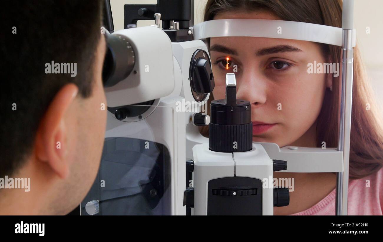 Ophthalmology treatment - a young woman with pink lips checking her ...