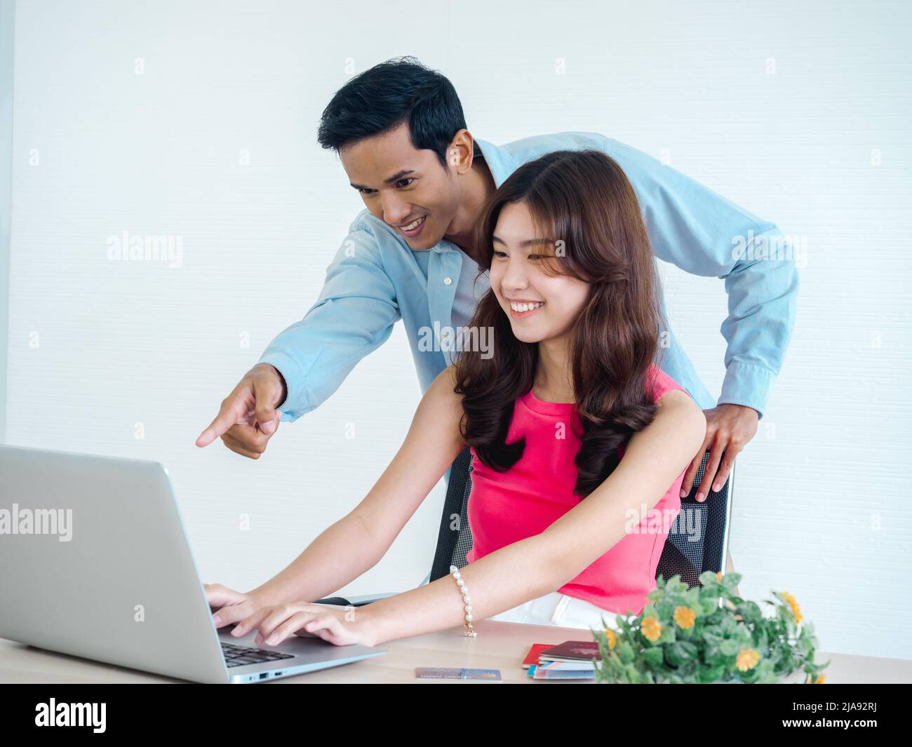 Happy Asian couple, young woman and man using tablet and laptop ...