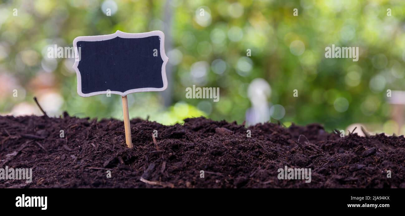 Empty label on Soil close up, blur nature background. Fertile dry dirt ...