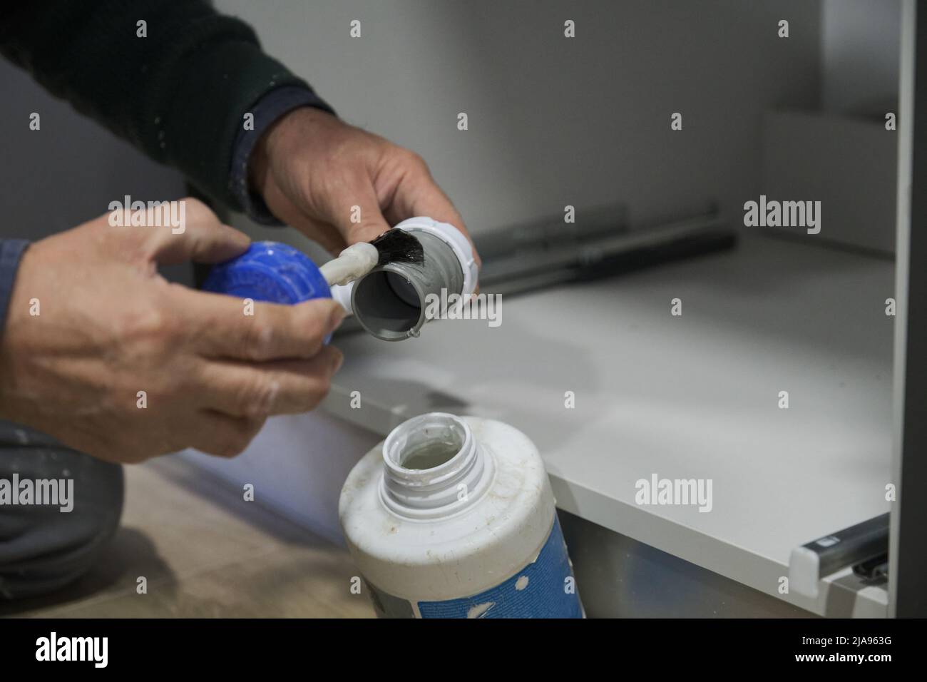 Mature plumber hands applying glue to a grey plastic pipe Stock Photo ...