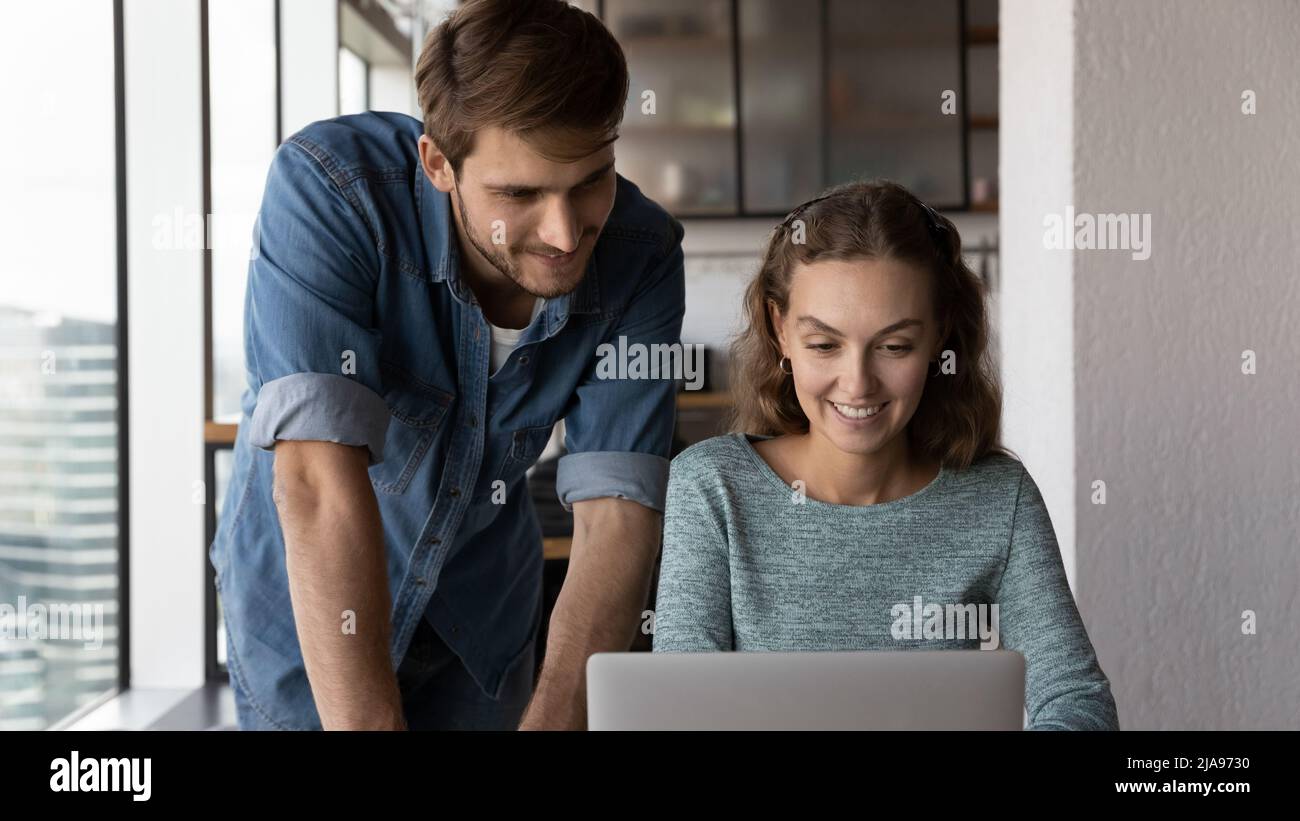 Happy employees working on project together, watching video ...