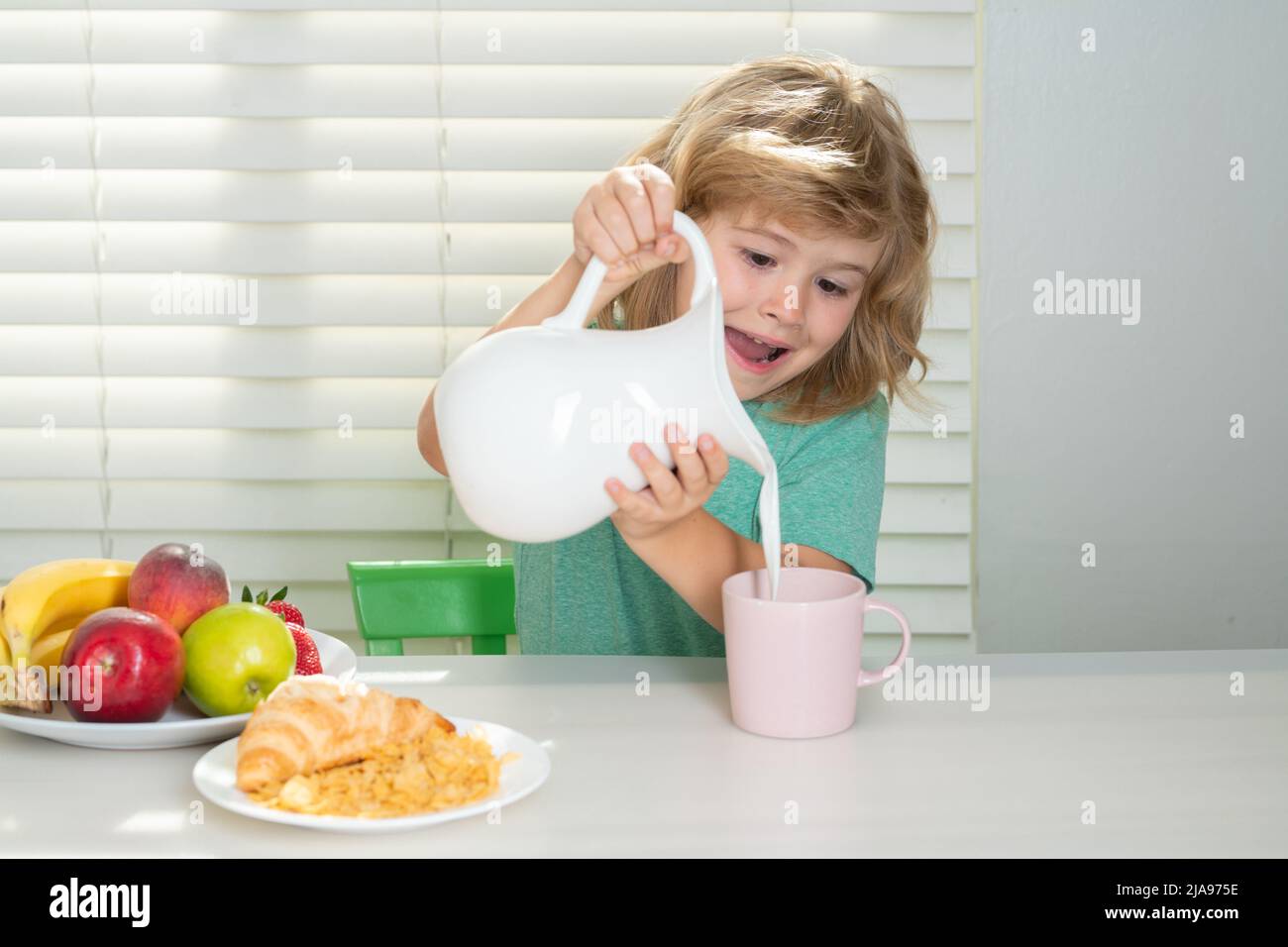 Fuuny little boy pouring whole cows milk for breakfast. Child boy ...