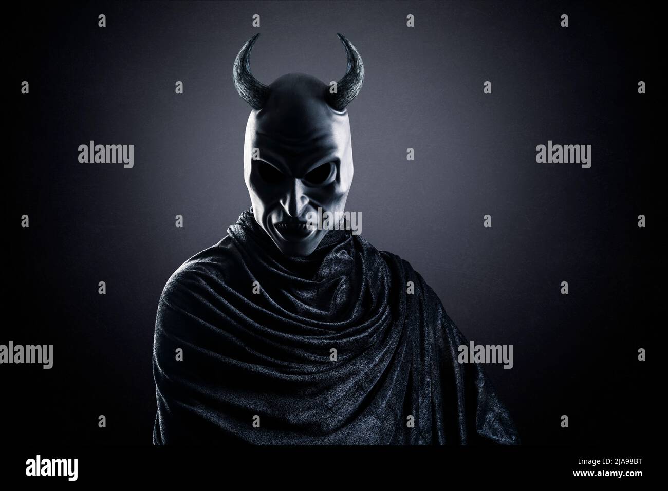 Horned demon at night over dark misty background Stock Photo - Alamy