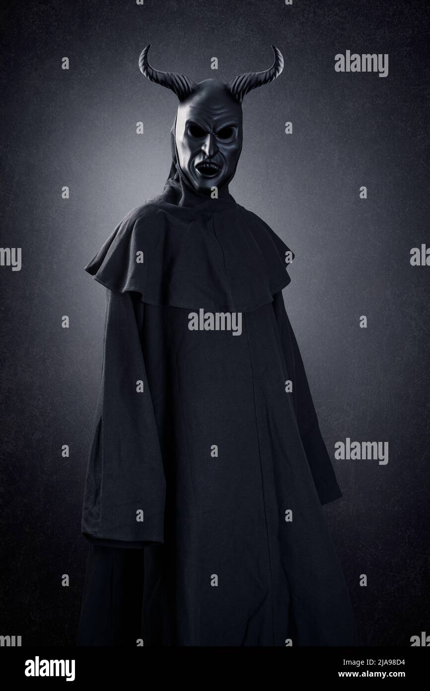 Horned demon at night over dark misty background Stock Photo - Alamy