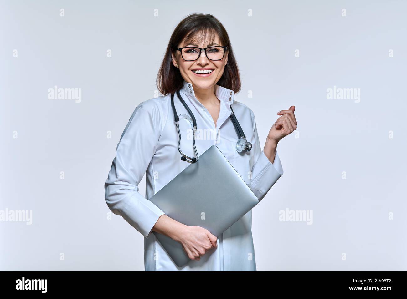 Portrait of female doctor with laptop, on light studio background Stock ...