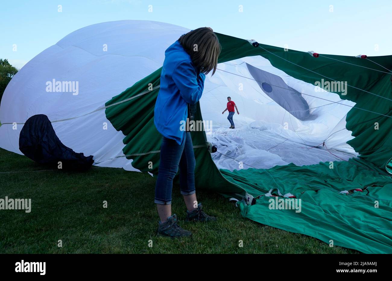 Members of a hot air balloon crew check their canopy prior to taking ...