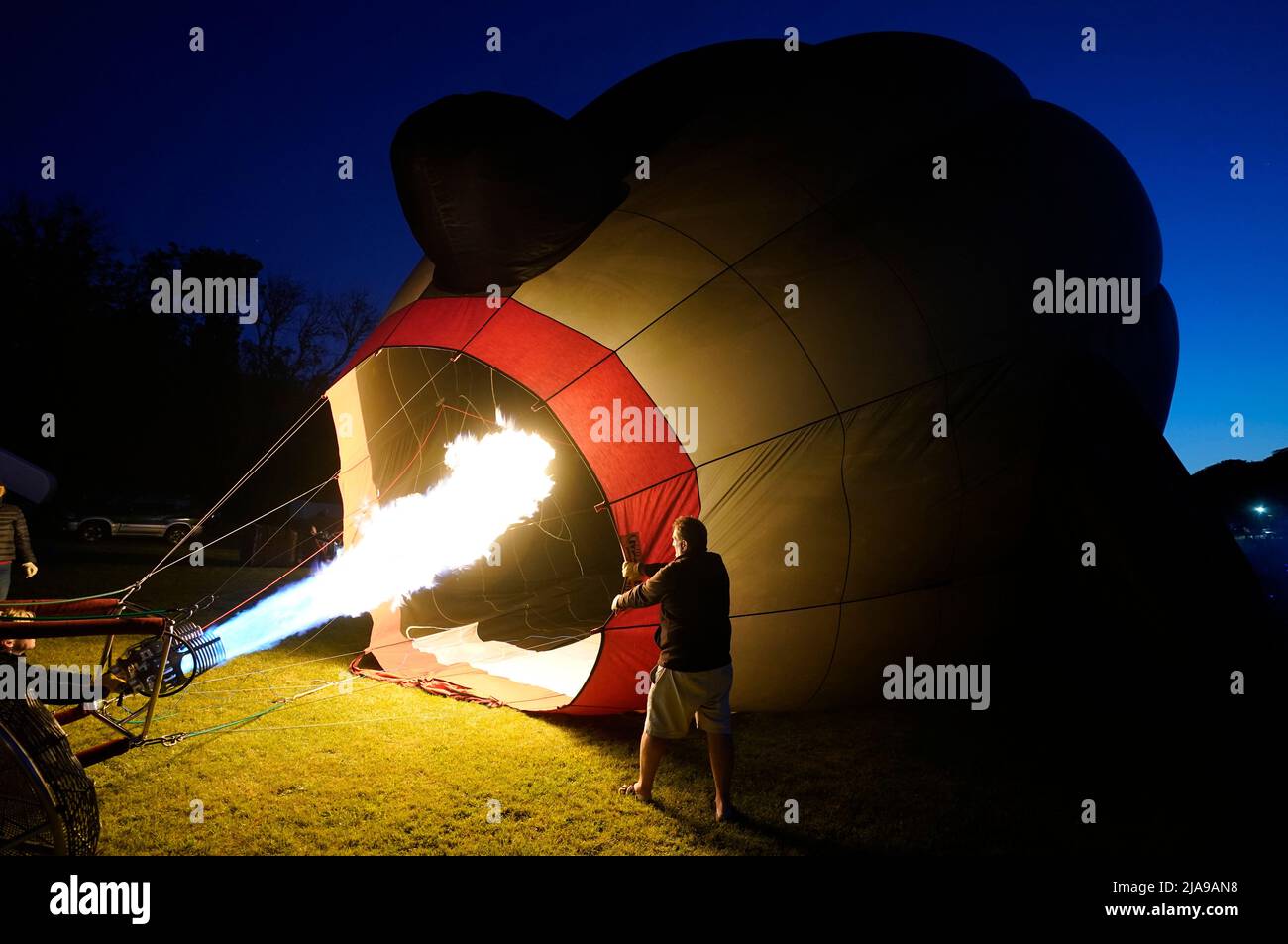 A hot air balloon crew prepare their balloon to take part in a night ...