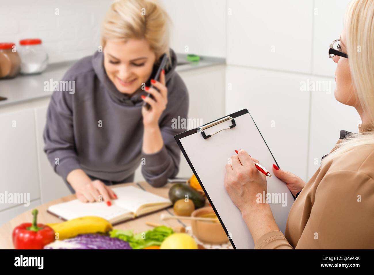 A smiling nutritionist advises a young patient woman on proper ...