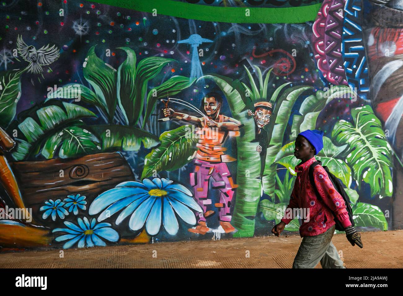 Nairobi, Kenya. 28th May, 2022. A Kenyan boy walks past the murals ...